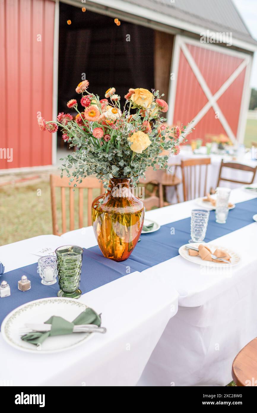 Fall flower arrangement in orange vase with barn Stock Photo - Alamy