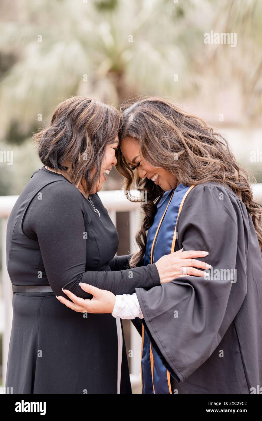 Mother and daughter laughing together while touching heads in gr Stock ...