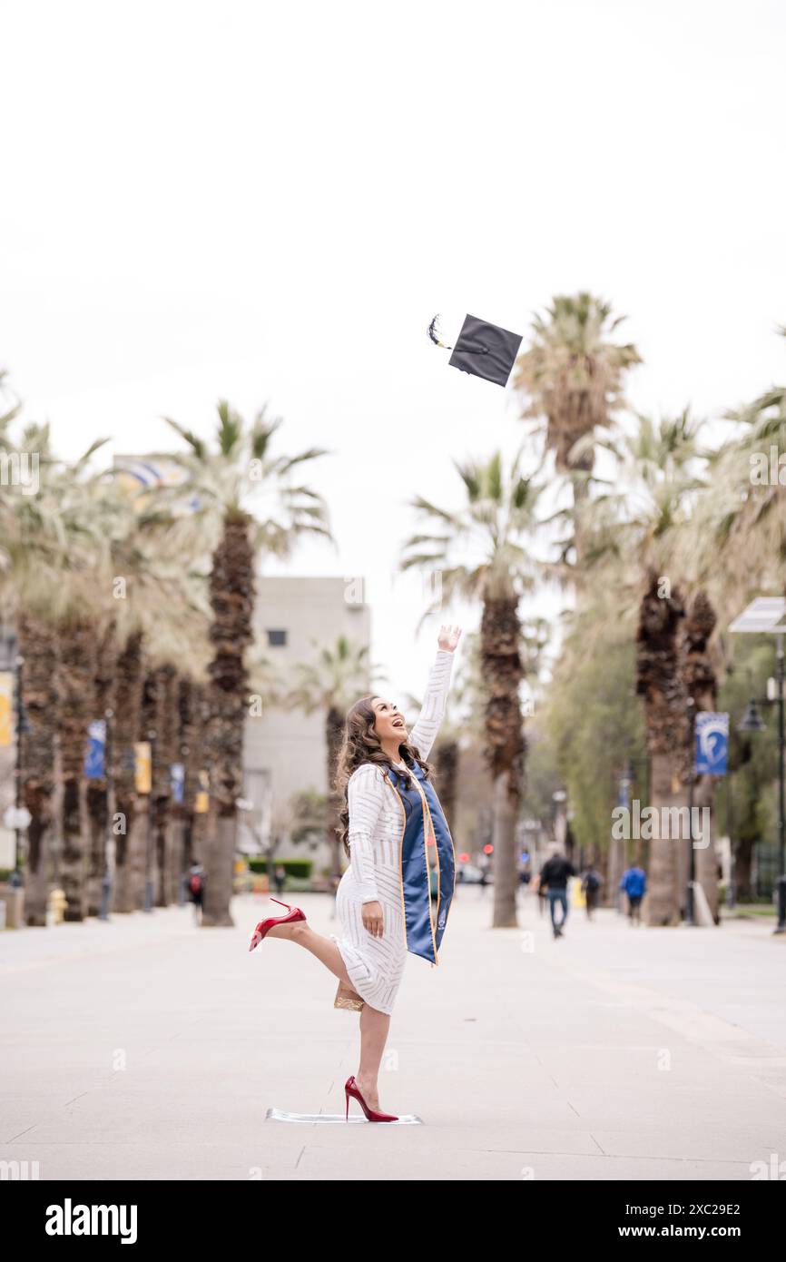 Asian graduate throwing cap in the air wearing red bottom shoes Stock ...