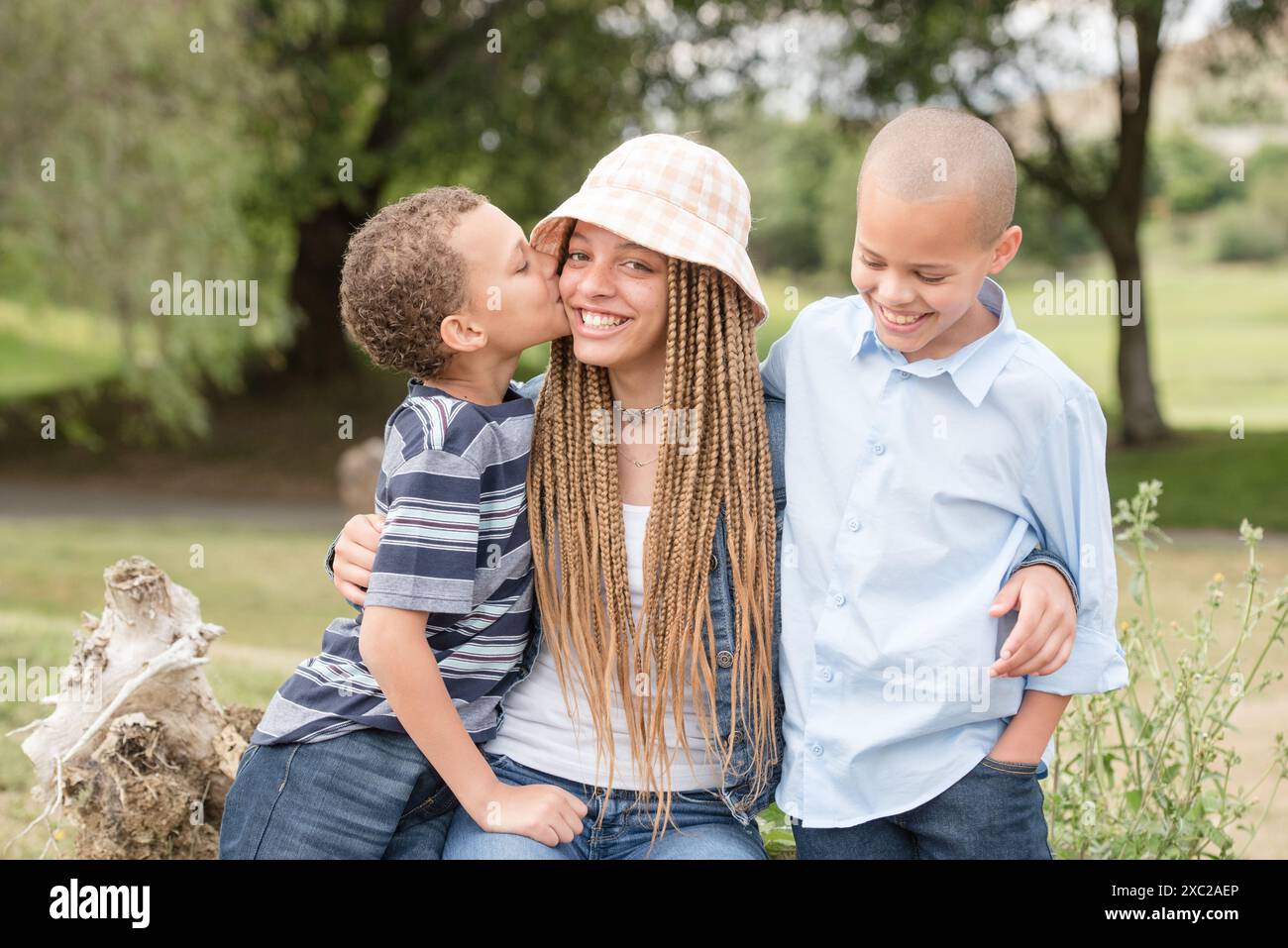 Brother kissing sister on the cheek while hugging each other Stock ...
