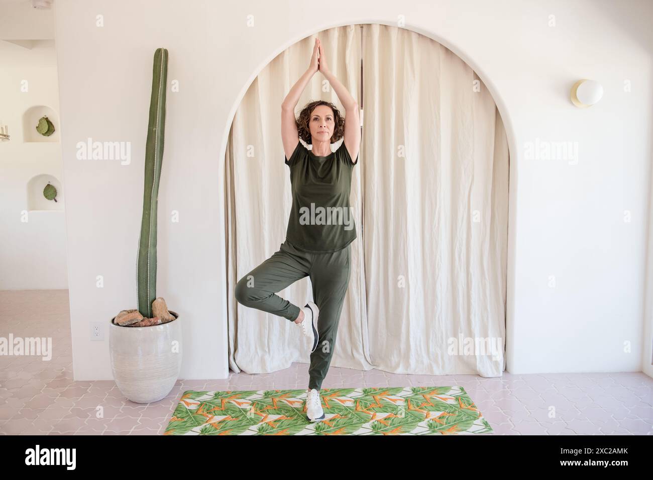 White women doing yoga in home with cactus behind Stock Photo - Alamy
