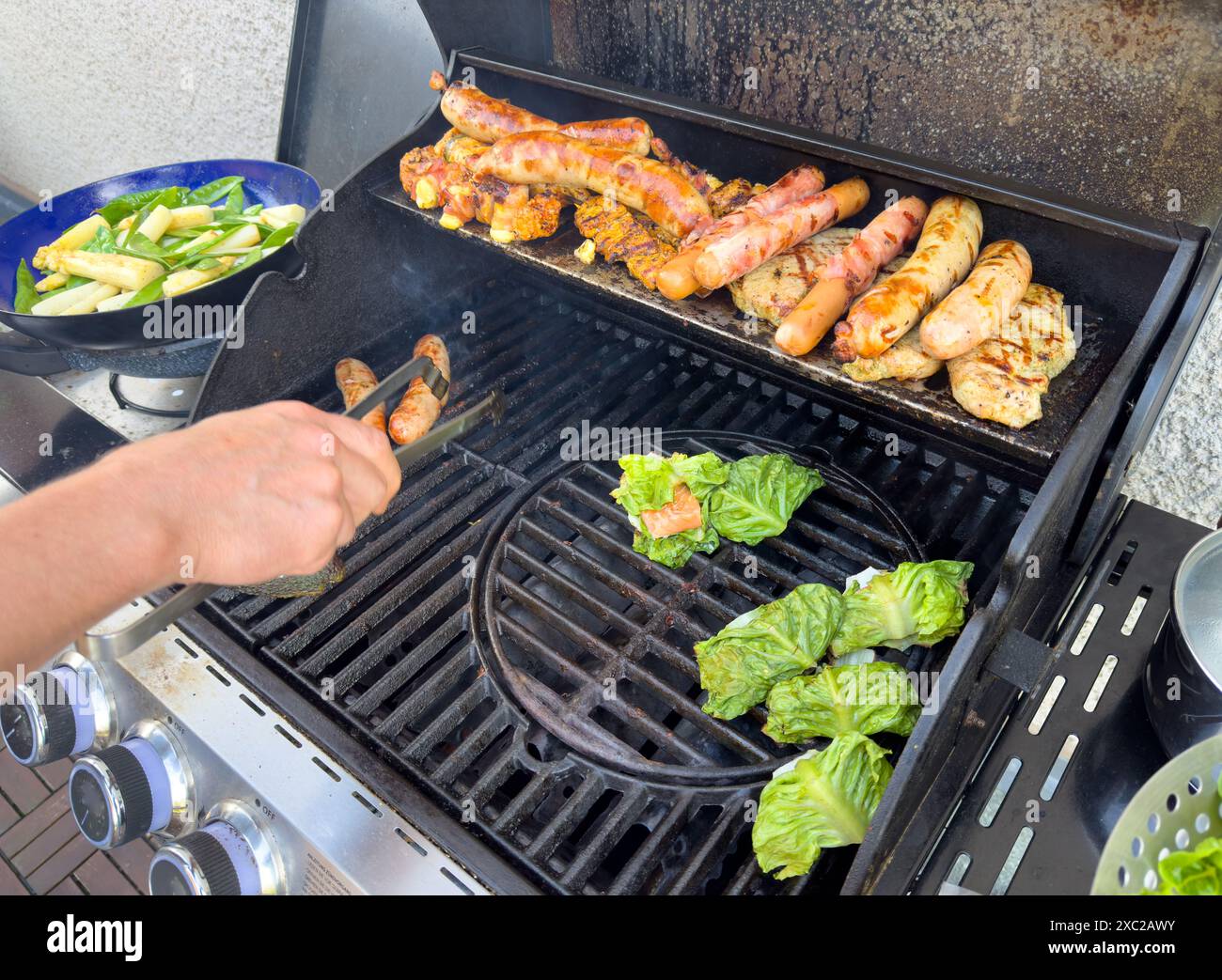 Gas grill grilled on a terrace with bratwurst and salad Stock Photo - Alamy