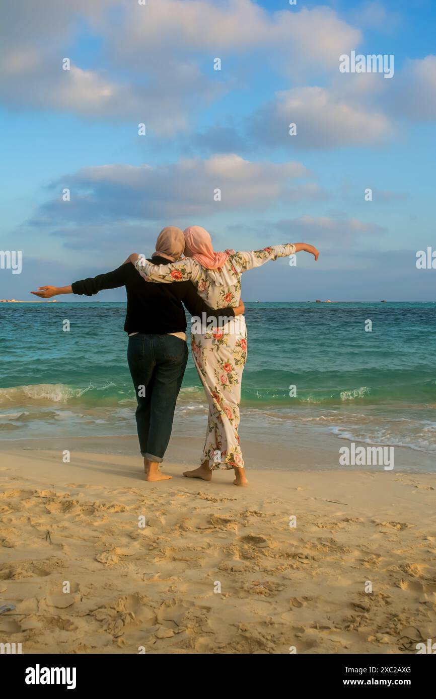 Muslim women in hijab enjoying leisure time at the beach Stock Photo ...