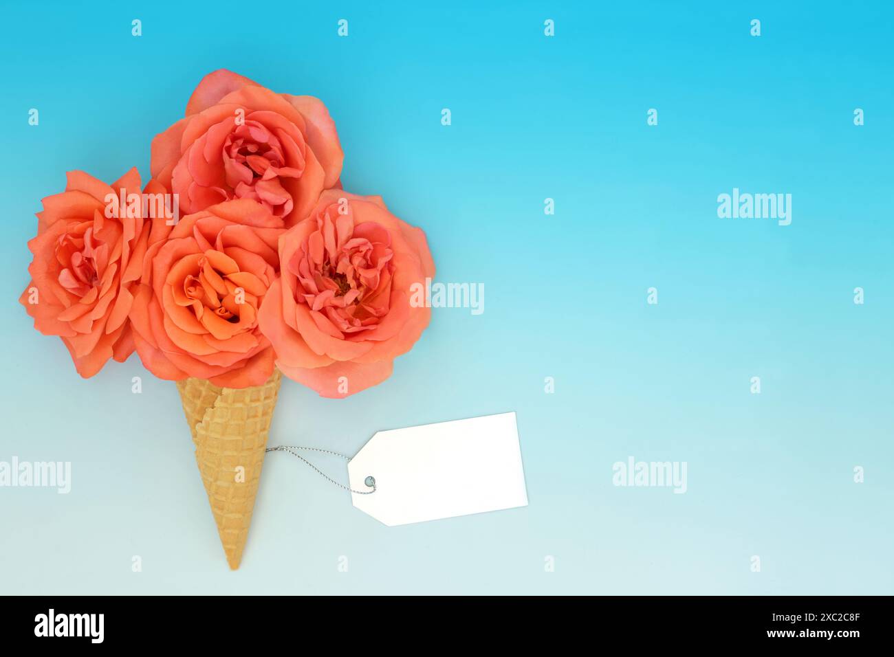 Surreal summer ice cream cone with orange rose flowers on gradient blue ...