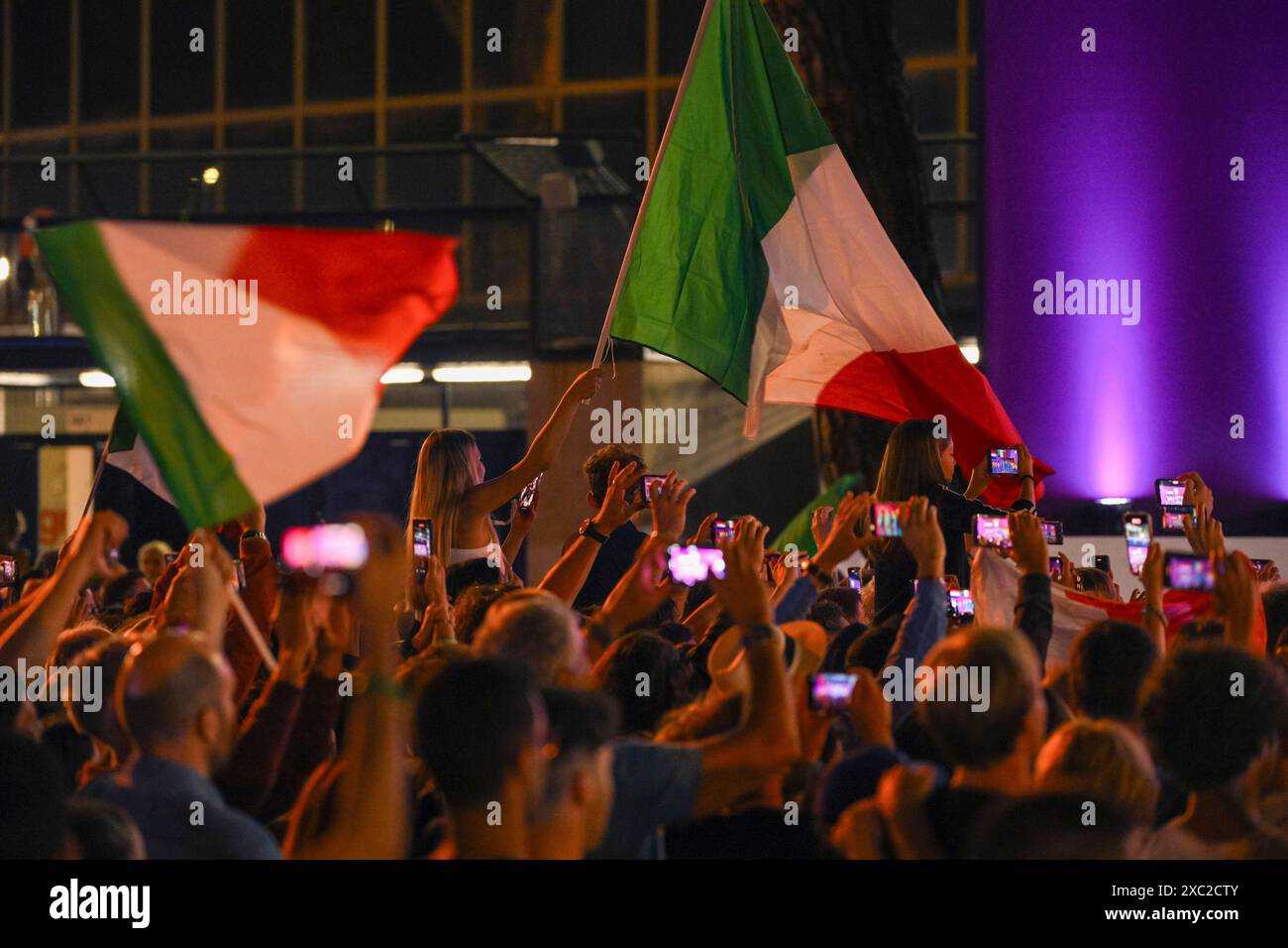People wave flags and take pictures during a medal ceremony at the ...