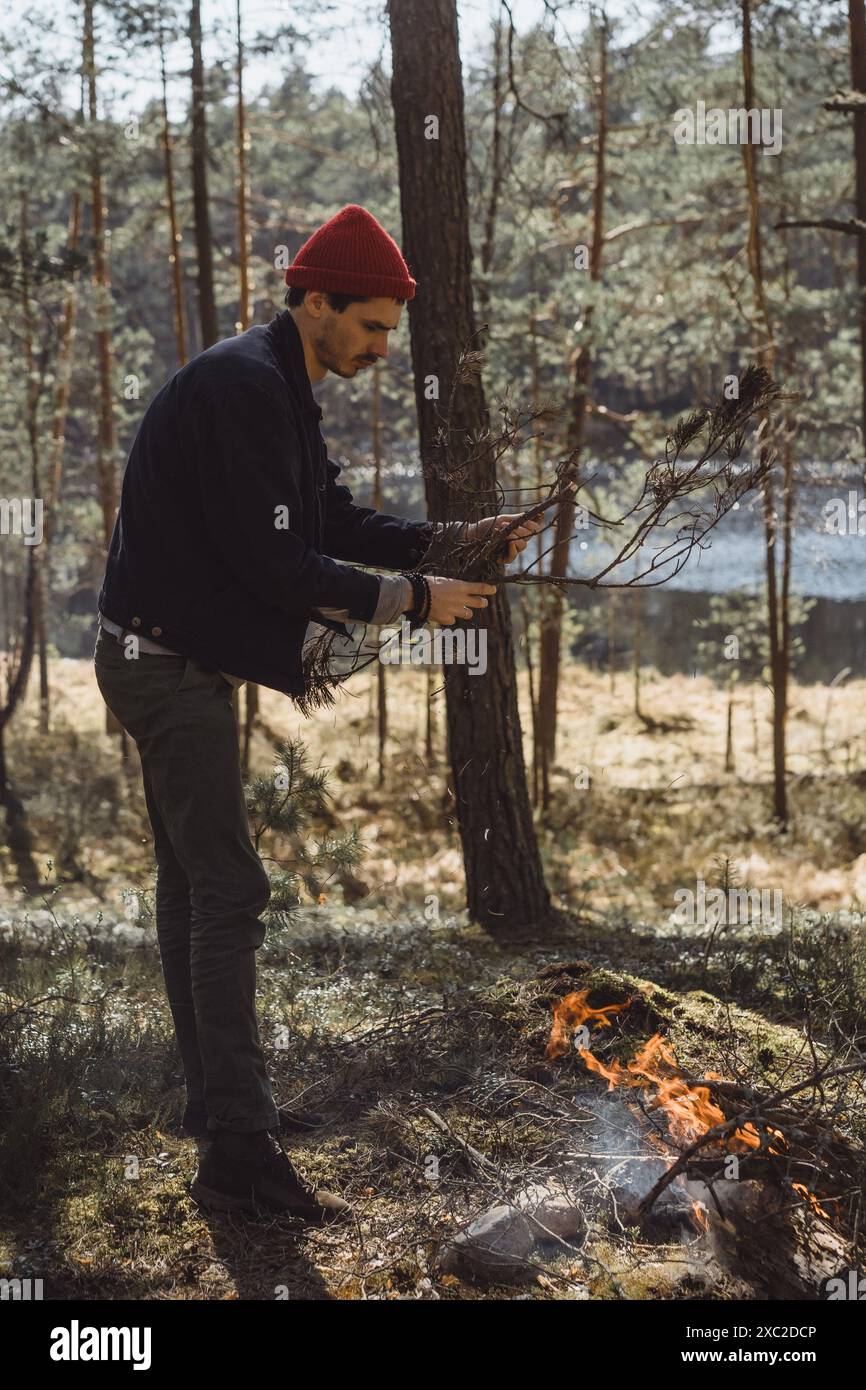 Man on a camping trip in a forest makes a fire Stock Photo - Alamy