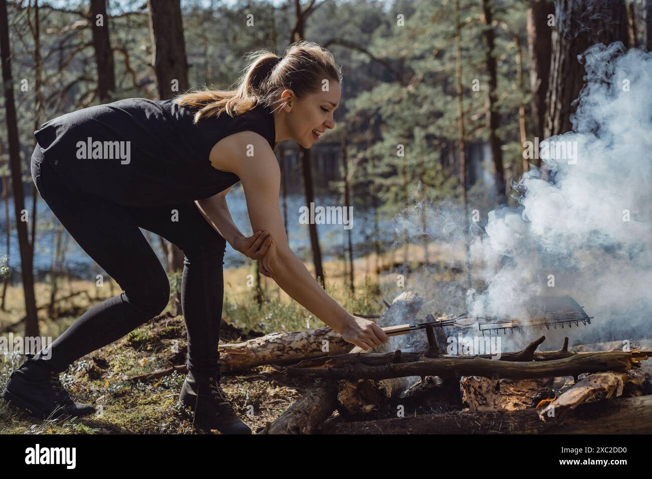 Woman is cooking on a bonfire. cooking on an open fire, camping Stock ...
