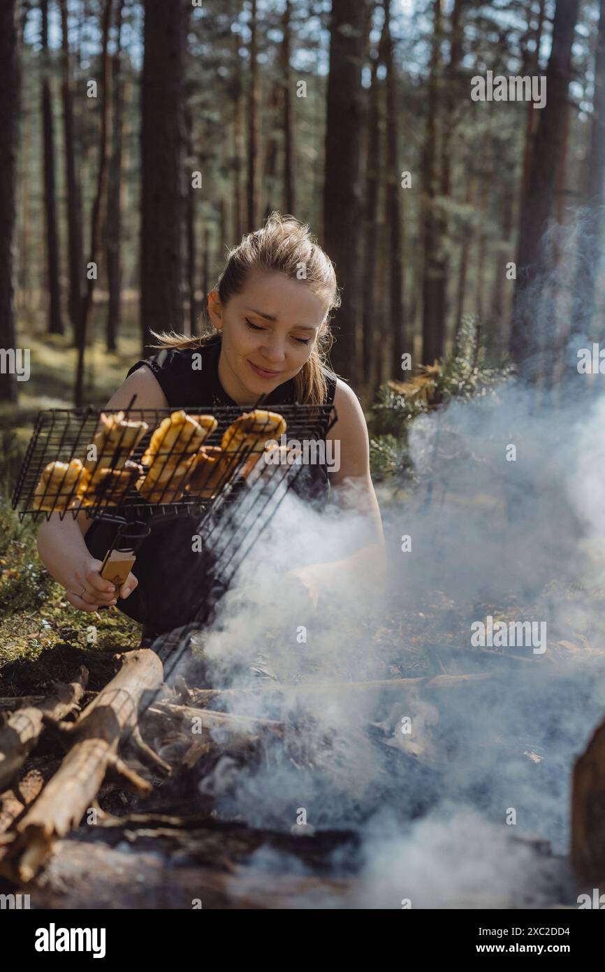 Woman is cooking on a bonfire. cooking on an open fire, camping Stock ...