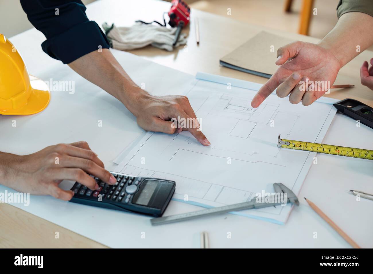 Architect, Engineers Collaborating on Blueprint Design with Tools and Safety Helmet on Desk ...
