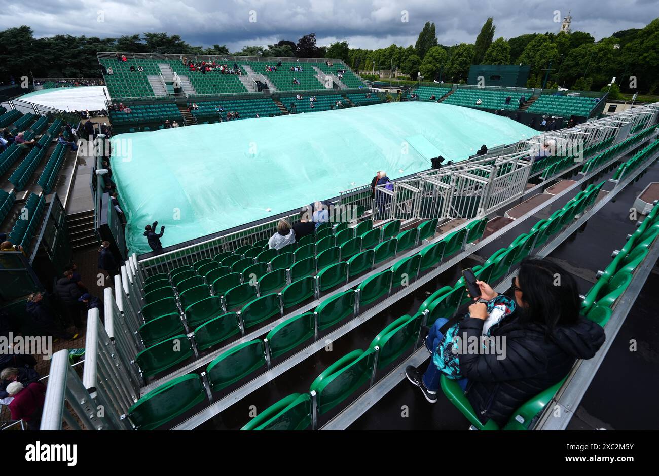 The ground staff cover the court with a rain cover on day five of the ...