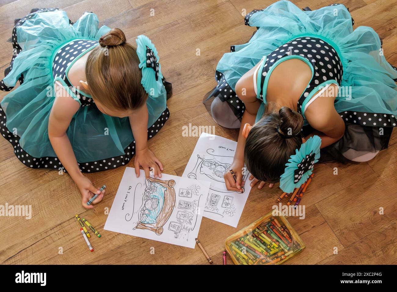 Two young girls dressed in costumes coloring together Stock Photo - Alamy