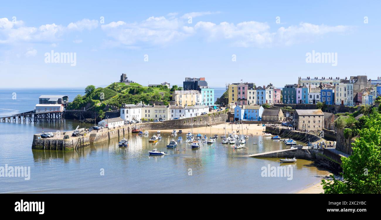Small boats in Tenby Harbour and Tenby Harbour beach at high tide with ...