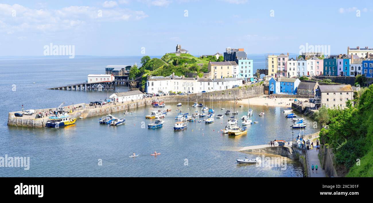 Small boats in Tenby Harbour and Tenby Harbour beach at high tide with ...