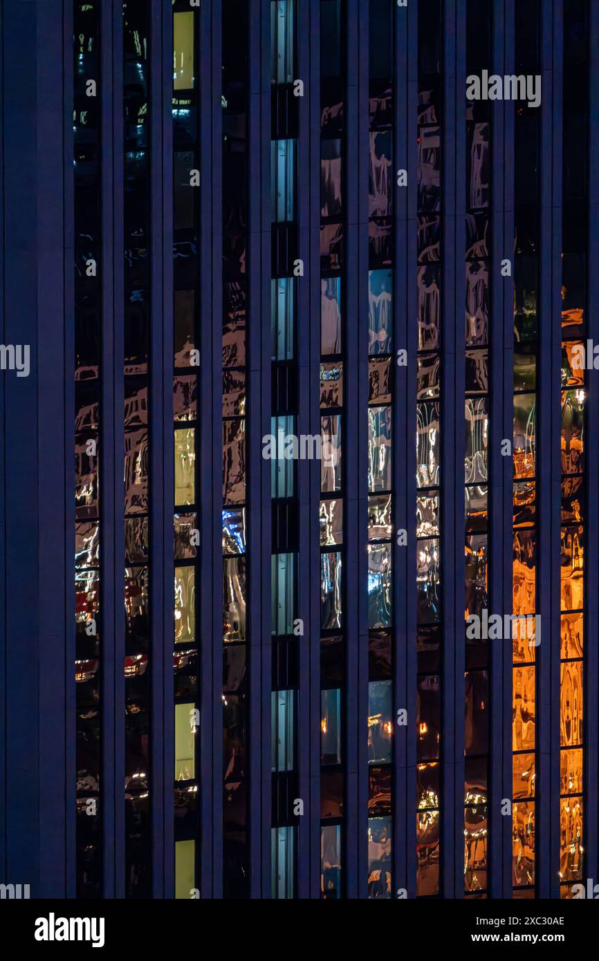 A close-up view of a modern building's glass facade reflecting city ...