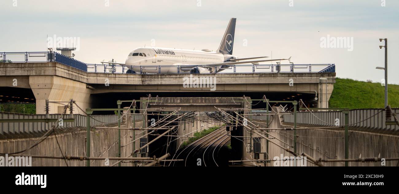 An Lufthansa passenger airplane on a runway bridge above a railway ...