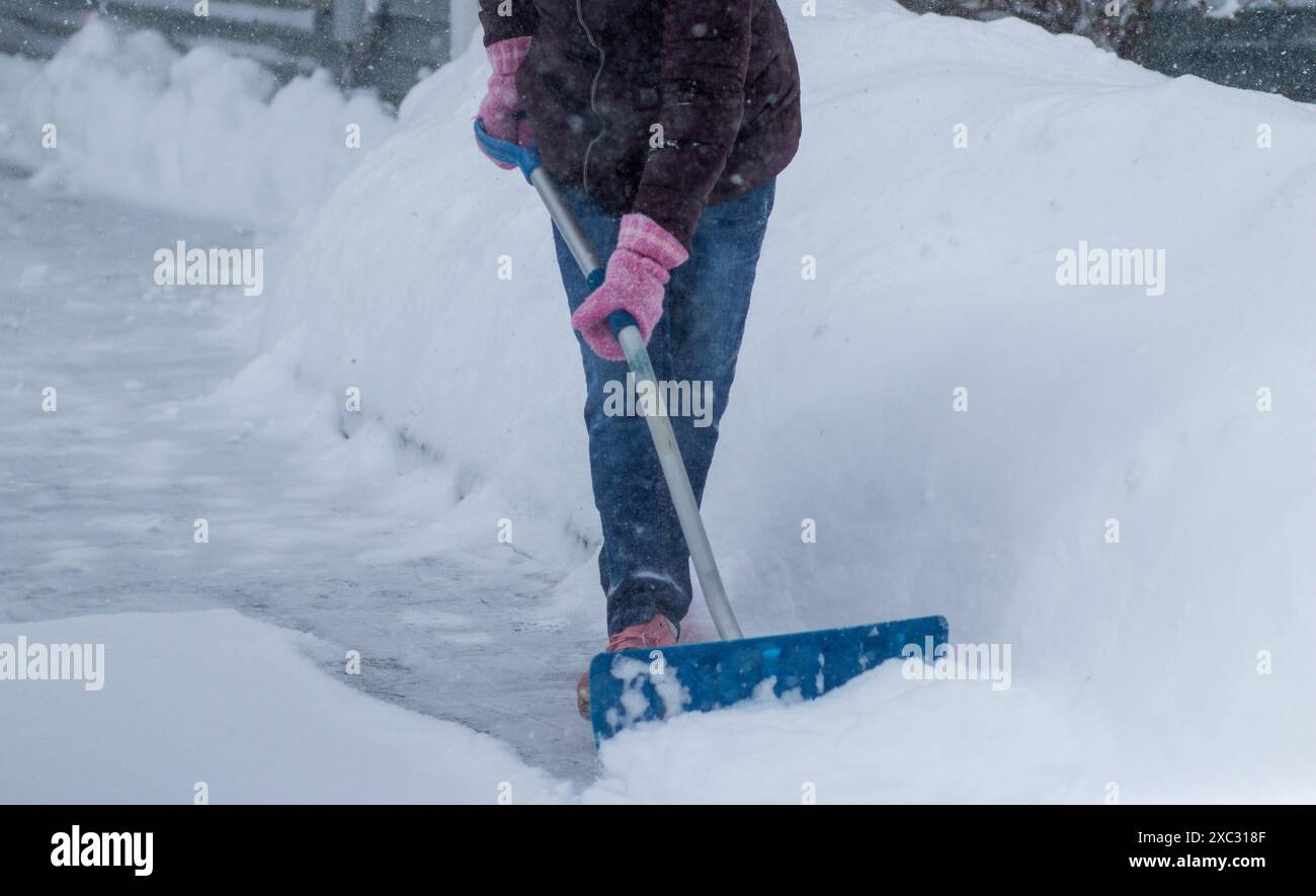 Women shoveling over two feet of snow off her driveway wearing pink ...