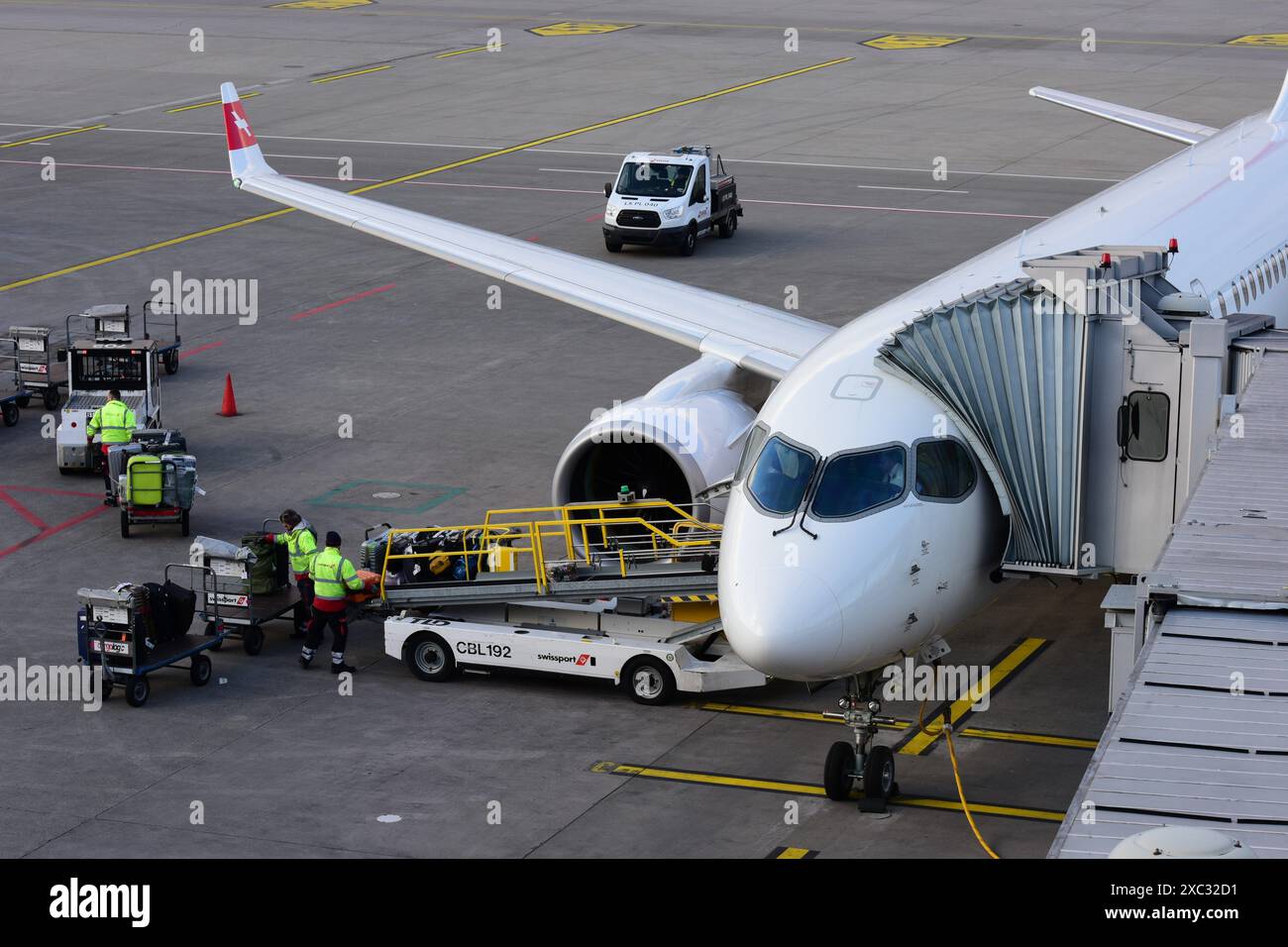 Ground crew loading luggage onto an airplane at an airport gate Stock ...