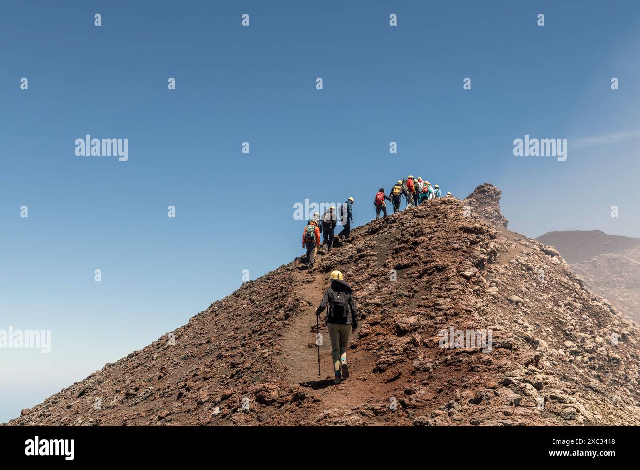 A guided tour group visiting the active summit craters of Mount Etna ...