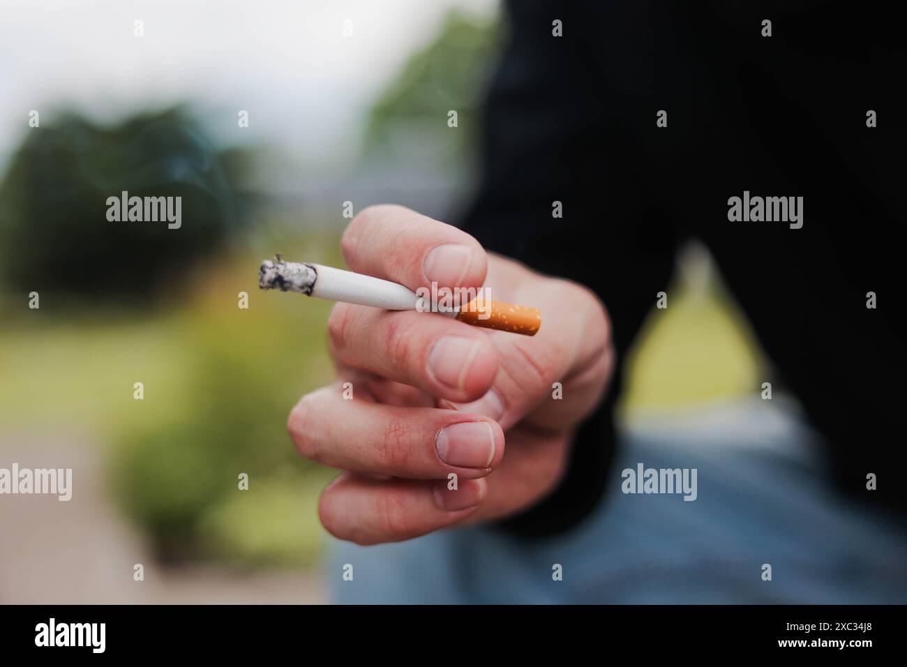 Cigarette in hand close up. Young man smoking a cigarette Stock Photo ...