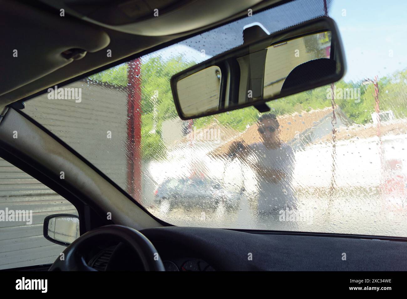 Cleaning the windshield and hood with a high pressure washer gun. View ...