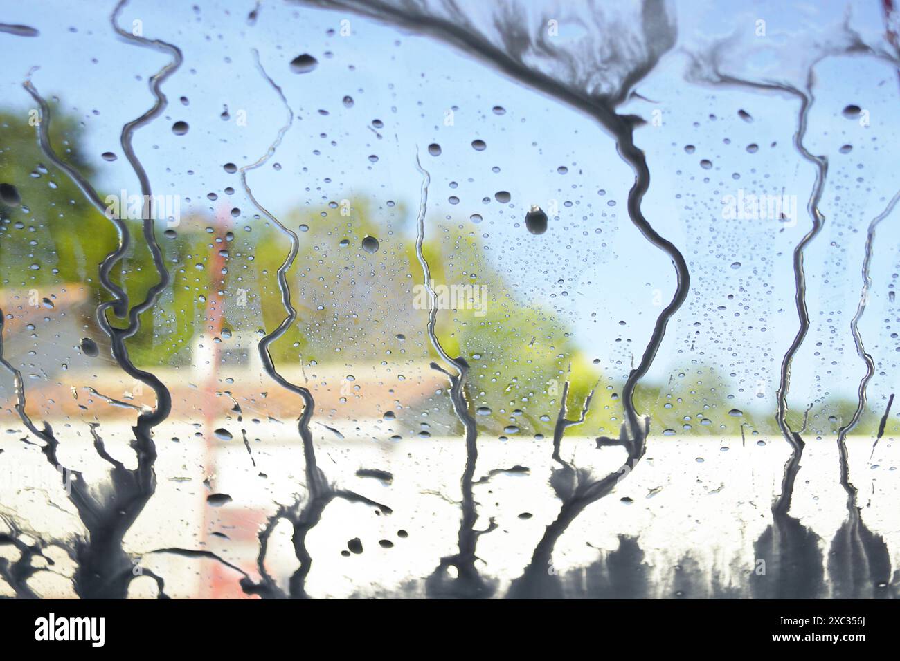 A car windshield covered with soapy streaks and water - close-up ...