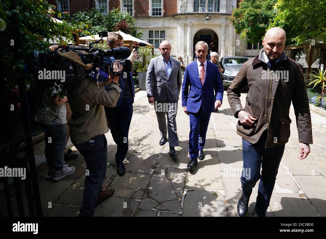 Reform UK leader Nigel Farage (centre) and his security detail leave ...
