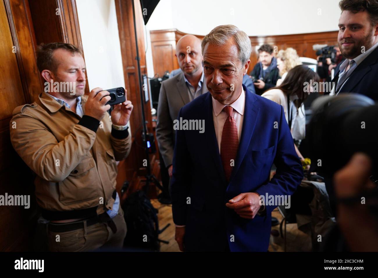 Reform UK leader Nigel Farage (centre) and a member of his security ...