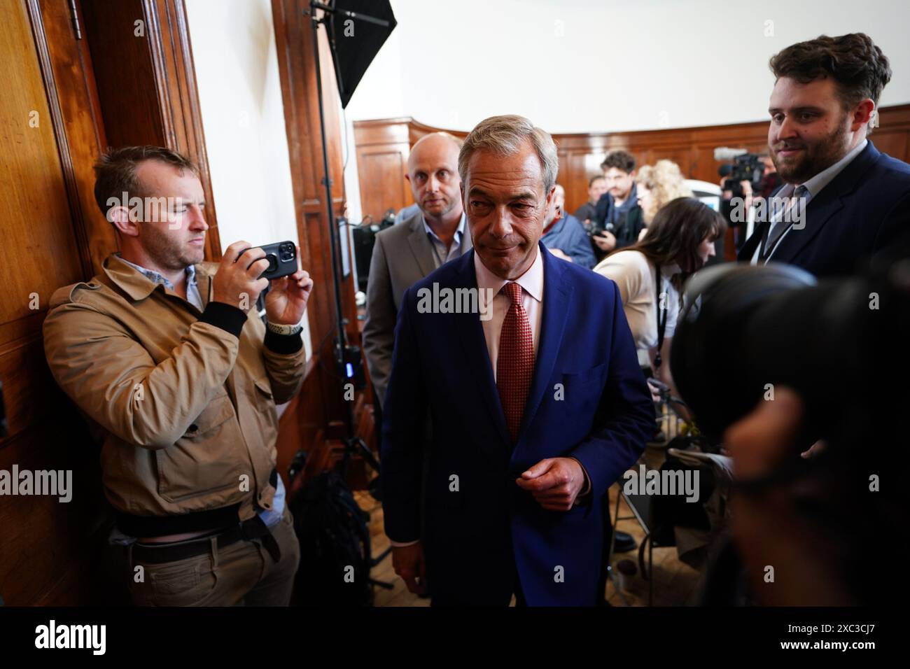 Reform UK leader Nigel Farage (centre) and a member of his security ...