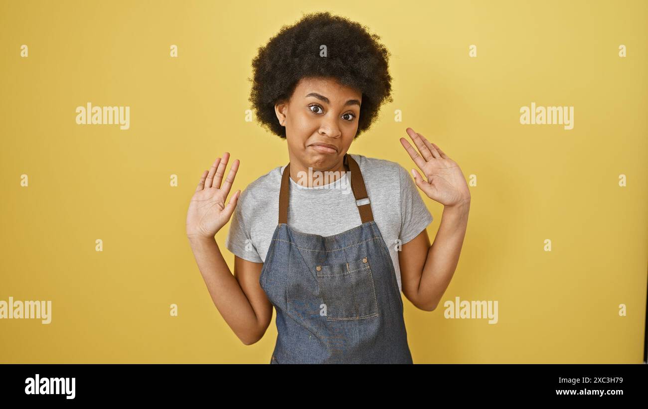 A perplexed african american woman with curly hair stands against a ...