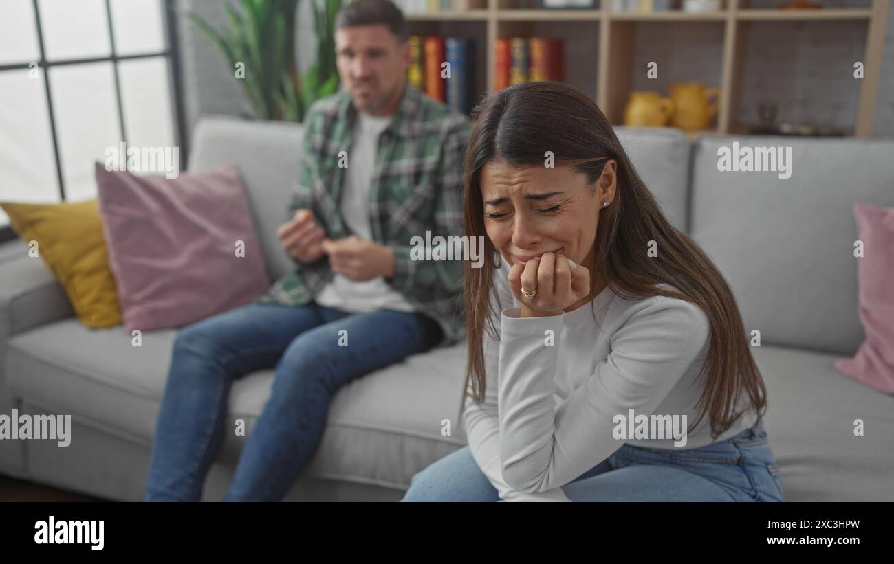 A woman crying in a modern living room with a man comforting her ...