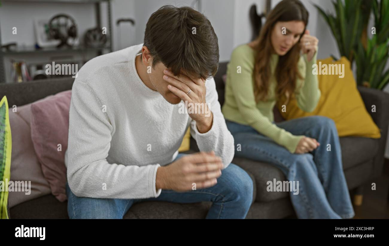 Stressed couple in disagreement sitting apart on sofa in modern living ...