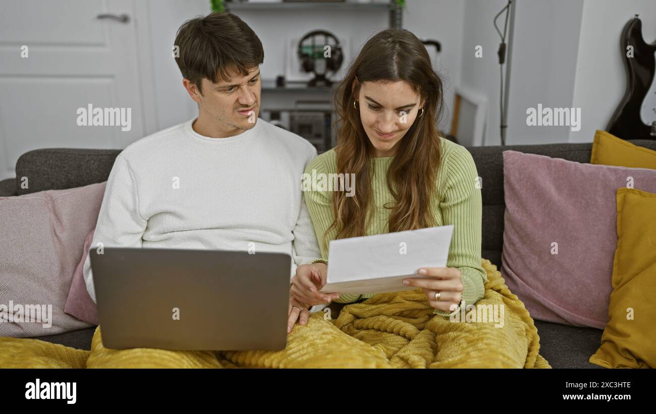 A man and woman review a document together, comfortably seated on a ...