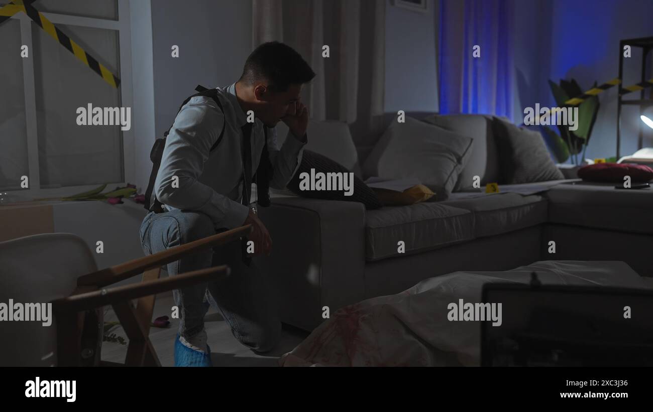 Distraught man sitting in a dimly lit crime scene living room with ...