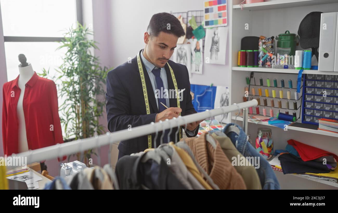 Handsome hispanic man measuring fabric in a busy tailor shop with ...