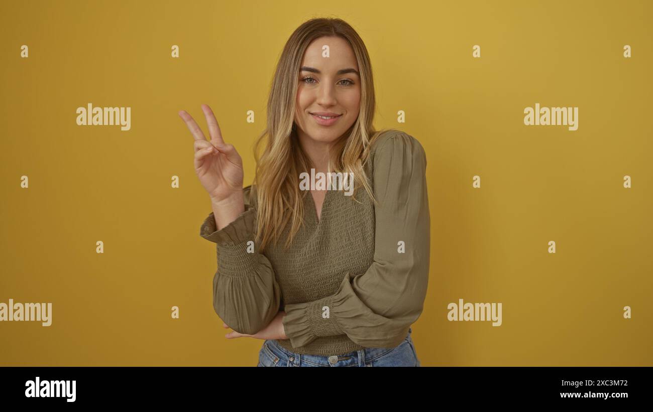 Young attractive blonde woman posing with a peace sign over an isolated ...