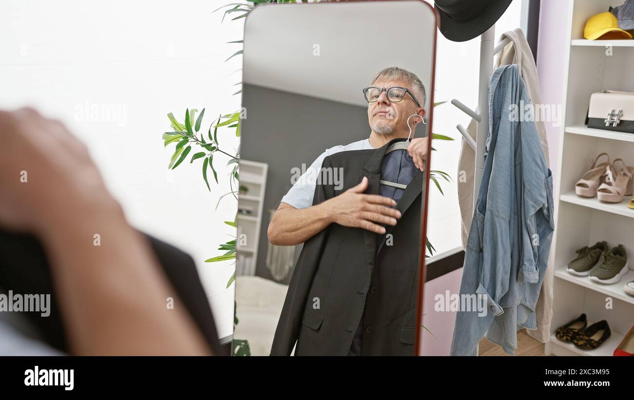 A mature man carefully tries on a suit in a well-organized dressing ...