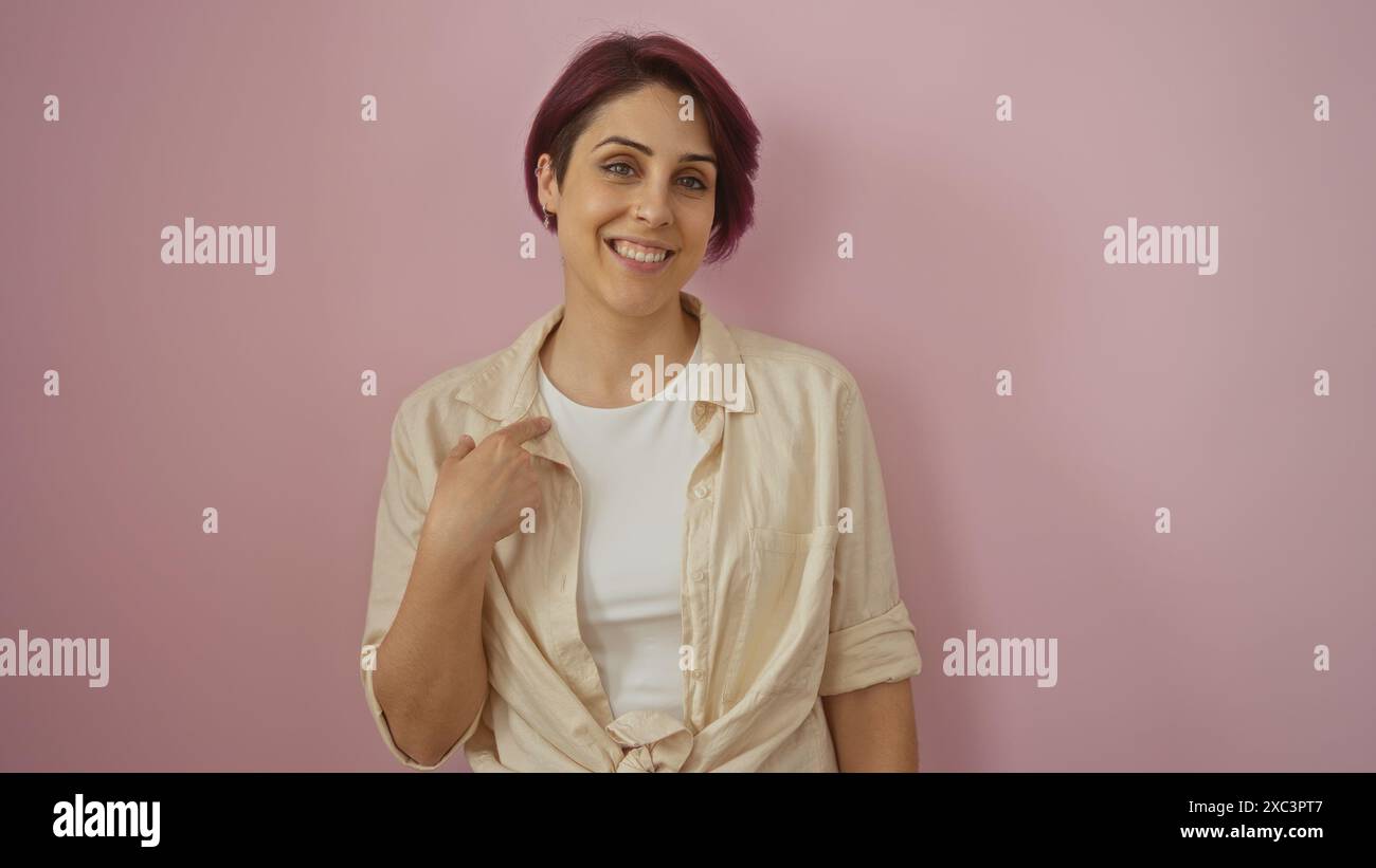 A beautiful young adult woman with short hair points at herself while ...
