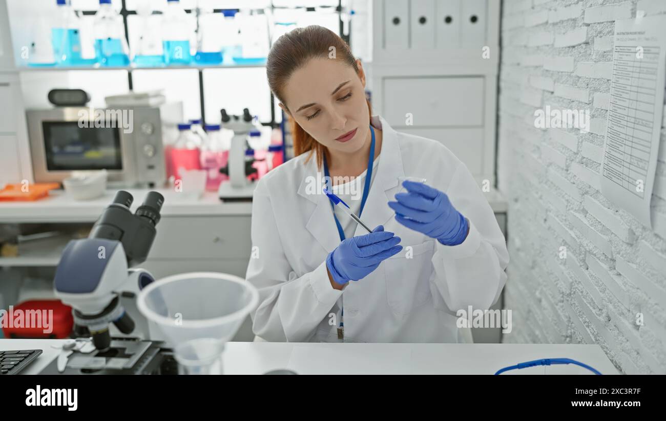 A focused young woman scientist in a white lab coat performs an ...