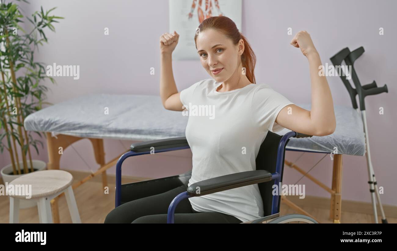 Redheaded woman flexing muscles in a rehabilitation clinic interior ...
