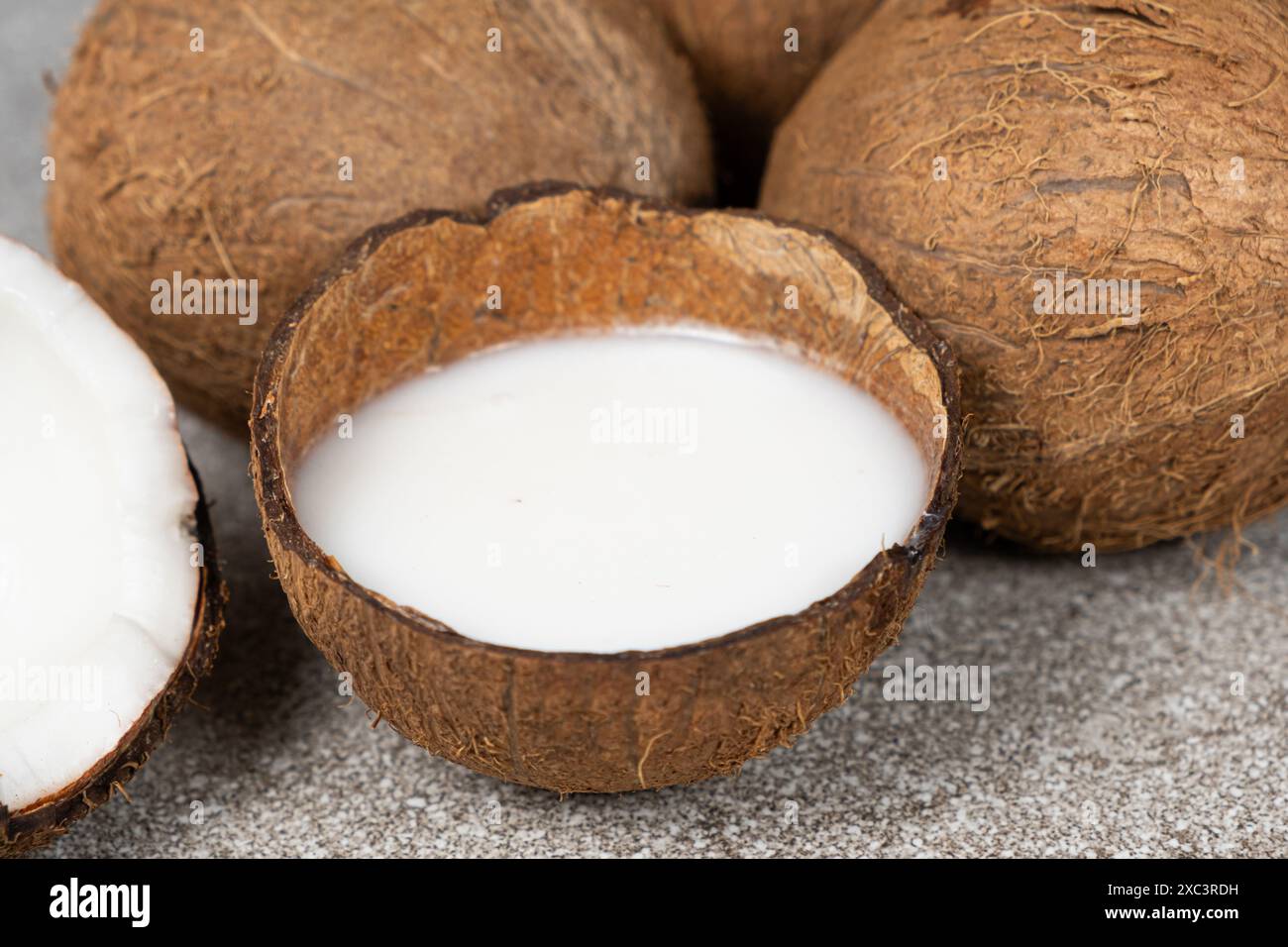 Coconut milk in coconut shell on grey background Stock Photo - Alamy