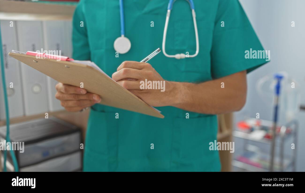 Hispanic male healthcare professional taking notes on a clipboard in a ...