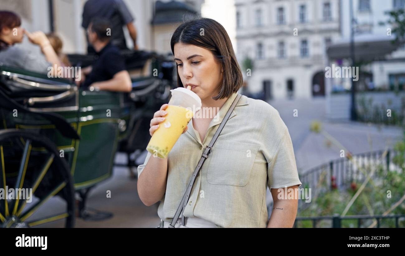 Young beautiful hispanic woman drinking bubble tea in the streets of ...