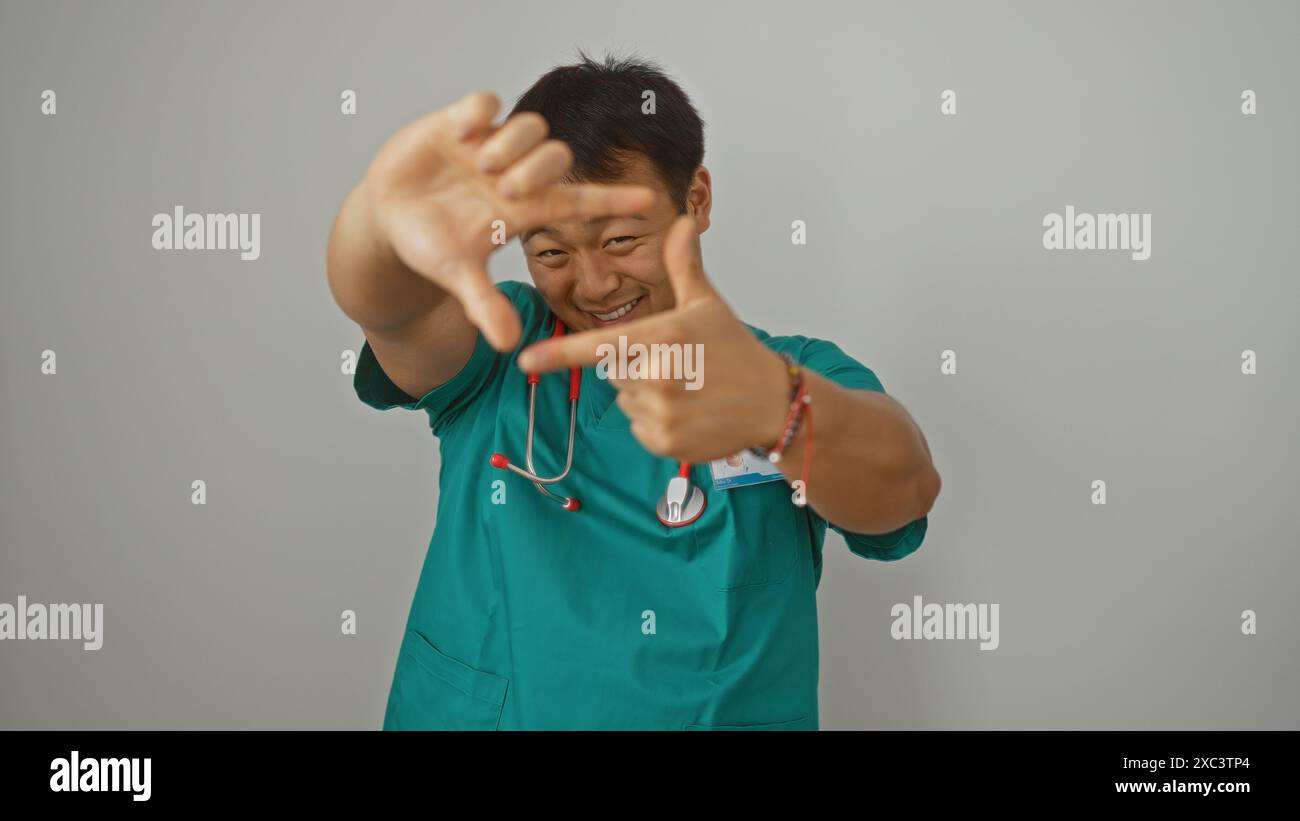 Young chinese male doctor poses playfully in a teal uniform with a ...