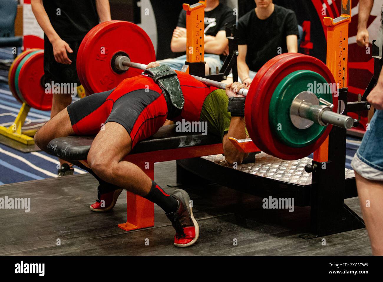 man athlete perform bench press surrounded by assistants at ...
