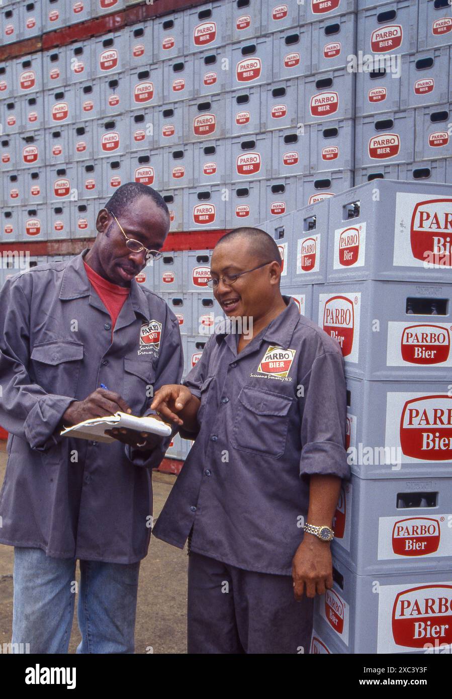 Suriname, Paramaribo - Factory workers discuss the storage of the ...