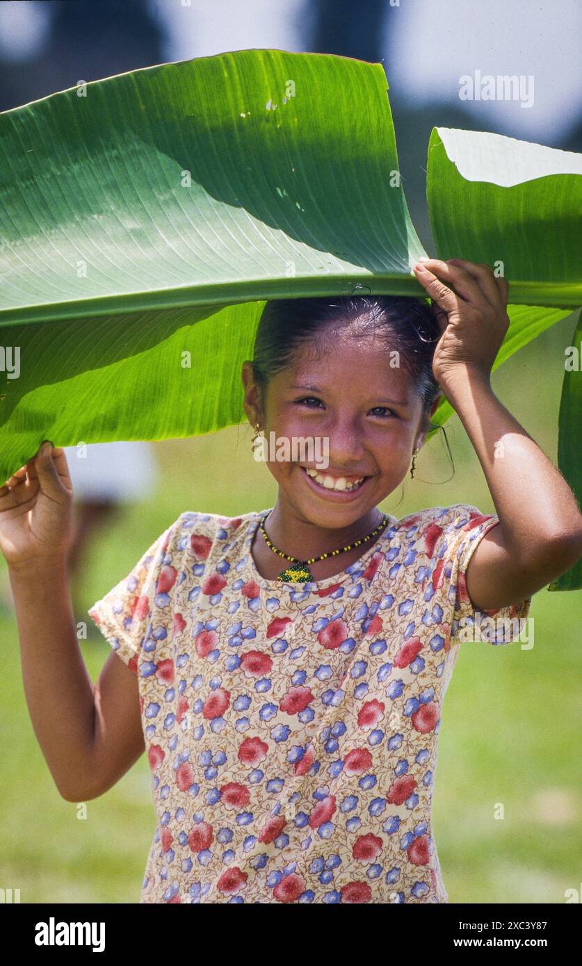 Suriname, Tepu. Girl of the Trio tribe with a banana leaf, covering her ...