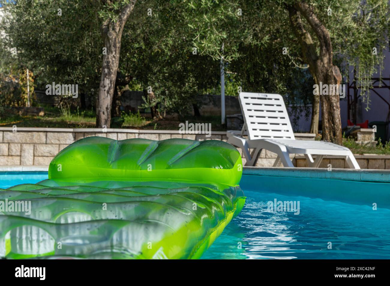 Green inflatable mattress in the pool Stock Photo - Alamy
