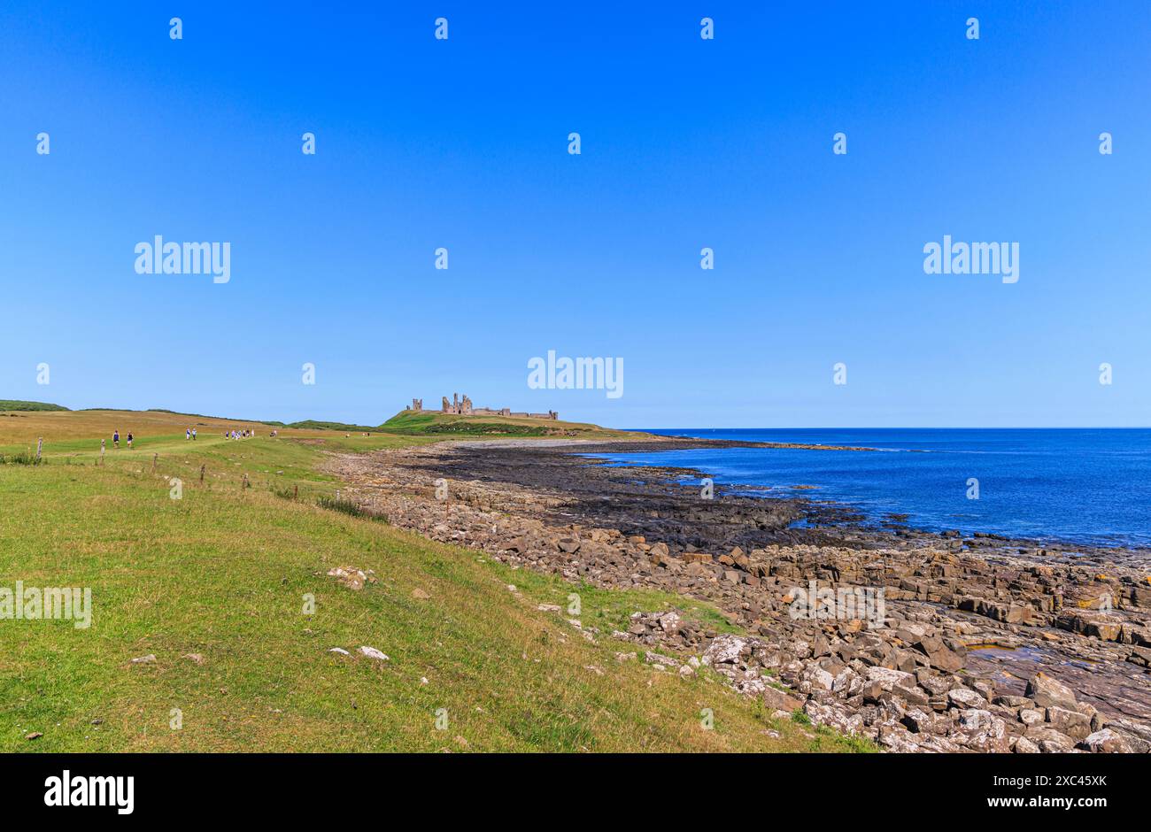 Panoramic shoreline view towards 14th century Dunstanburgh Castle ruins ...