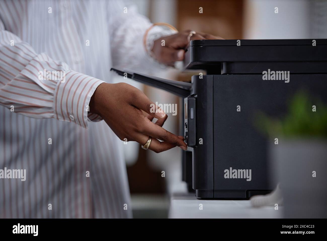 Side view close up on printer and female hands of office worker ...