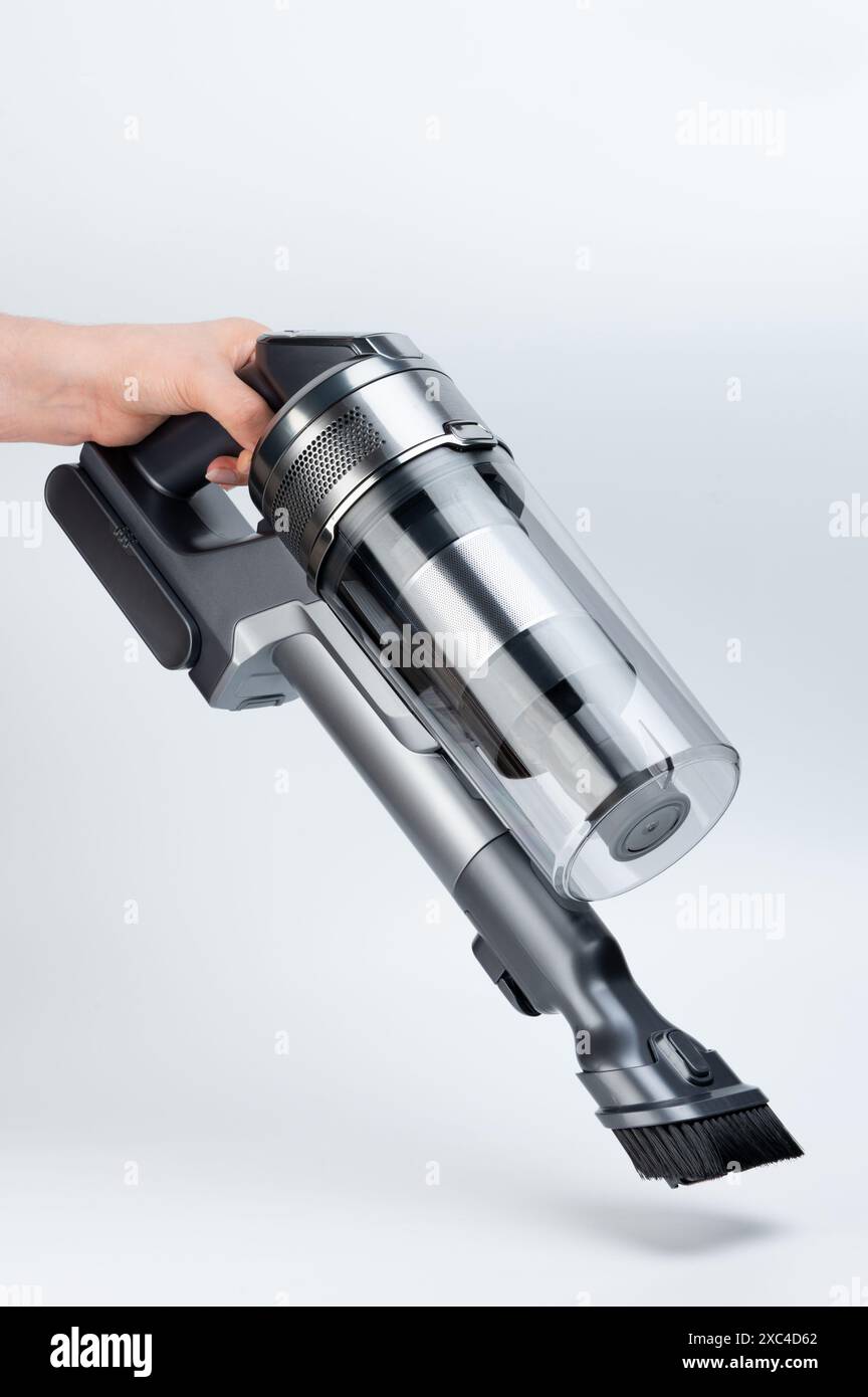 Wireless vacuum cleaner with dust brush side view in hand isolated on ...